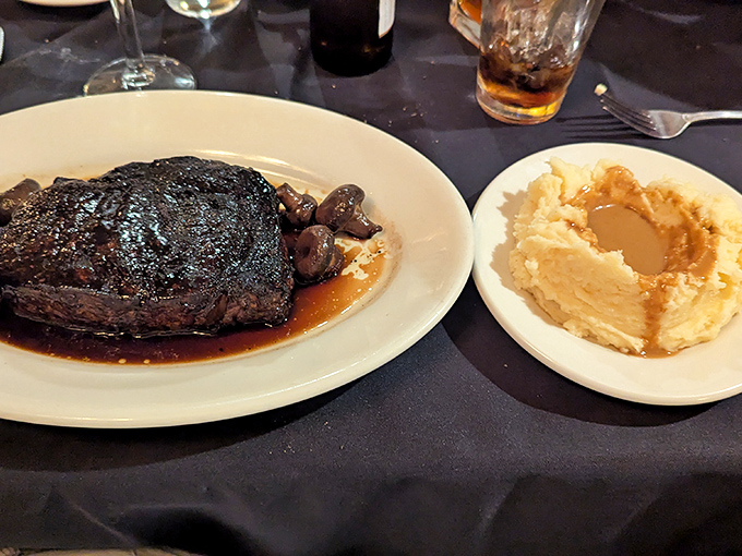 A steak so good it deserves its own entourage—here accompanied by mushrooms and mashed potatoes that know their supporting roles perfectly.