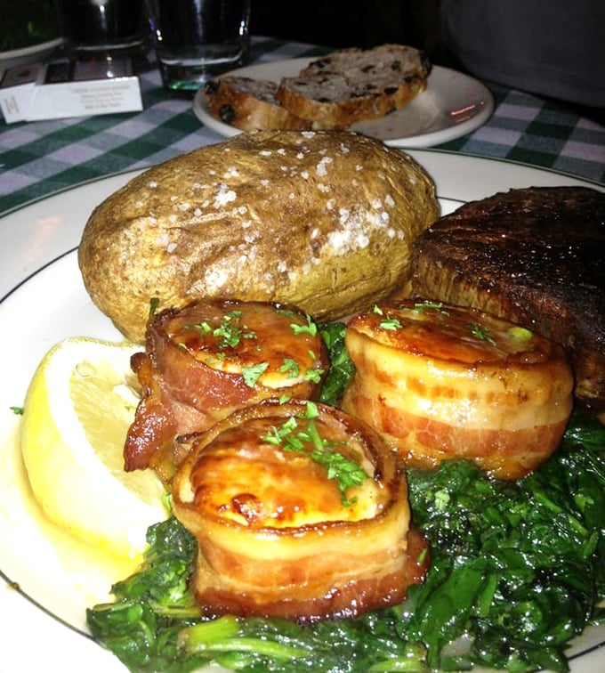 Bacon-wrapped scallops nestled beside a steak—proof that sometimes the best relationships are the ones that sizzle together.