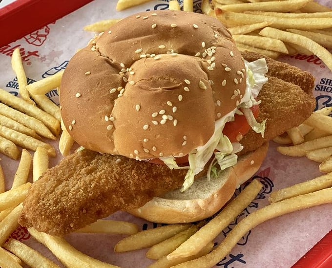 The fish sandwich arrives like an edible postcard from simpler times—crispy, generous, and surrounded by a golden moat of perfectly thin fries.