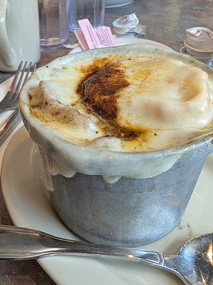 This isn't just French onion soup—it's a volcanic masterpiece of cheese and broth that demands a moment of respectful silence before diving in.