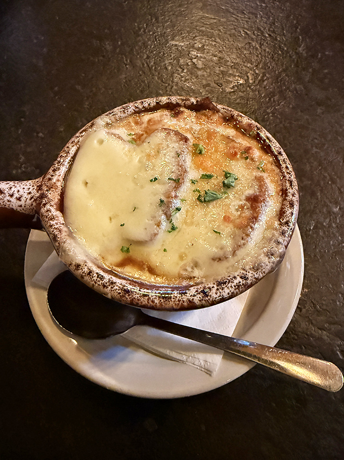 French onion soup that's having its Broadway moment—the cheese pulling a dramatic curtain call over caramelized onions and rich broth. Standing ovation guaranteed.
