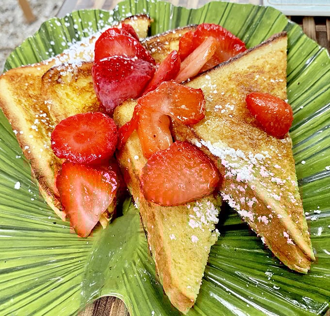 French toast that doesn't just arrive—it makes an entrance, dressed in strawberries and powdered sugar like it's heading to breakfast prom.