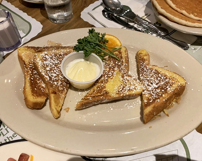 French toast that's achieved celebrity status—powdered sugar dusted like fresh snow, butter melting into those perfectly golden slices. Breakfast doesn't get more photogenic than this.