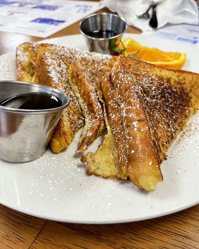 French toast that's achieved the perfect golden ratio—crispy edges, custardy center, and enough powdered sugar to leave evidence on your shirt.
