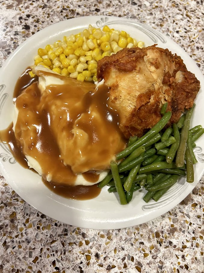 A plate that whispers "diet tomorrow" – mashed potatoes drowning happily in gravy alongside fried chicken that Colonel Sanders would salute.