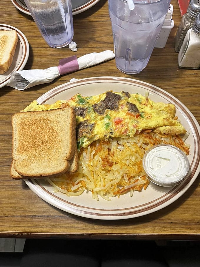 Breakfast architecture at its finest – a colorful omelet alongside hash browns with that perfect crisp-to-tender ratio that haunts your breakfast dreams.