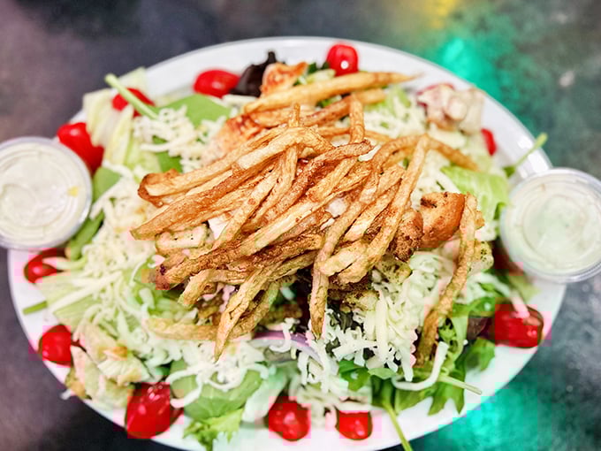 When a salad looks this good, even carnivores might pause—crispy fries crowning fresh greens in a delicious role reversal.