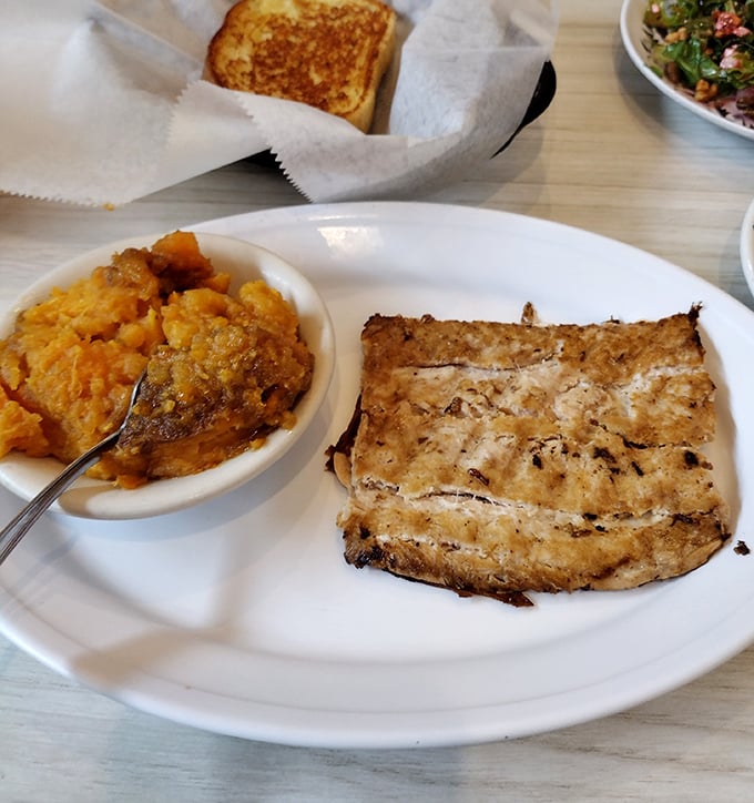 A perfectly grilled piece of fish alongside what might be the most comforting sweet potato casserole this side of Thanksgiving.