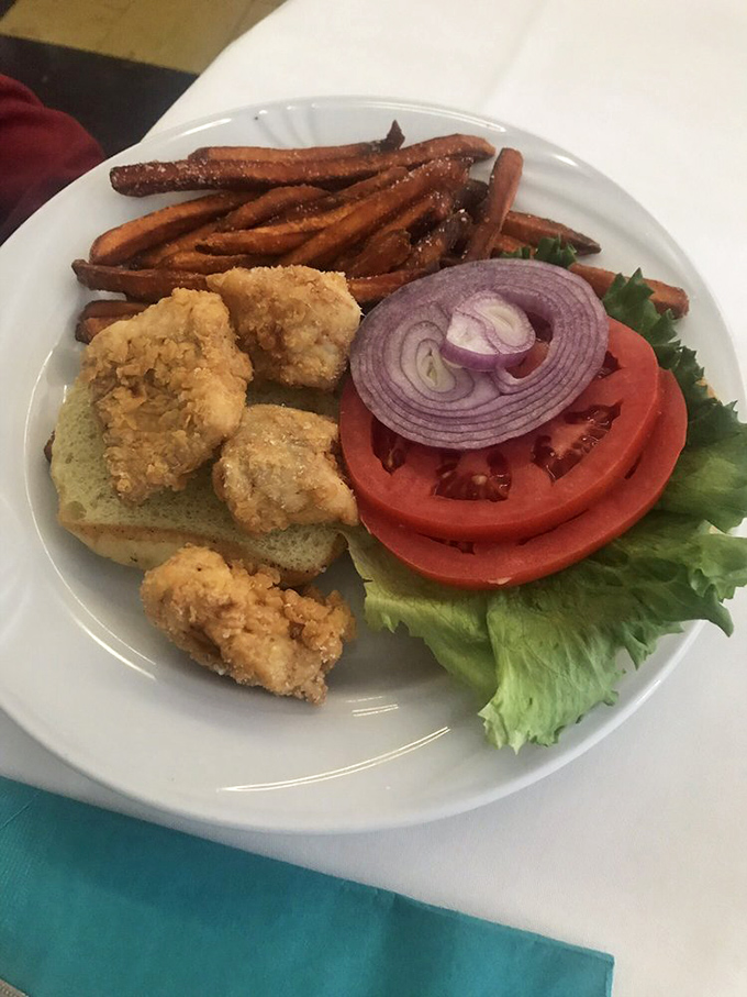 The fried grouper sandwich—where Gulf-fresh fish meets crispy perfection. Those sweet potato fries aren't just sidekicks; they're co-stars.