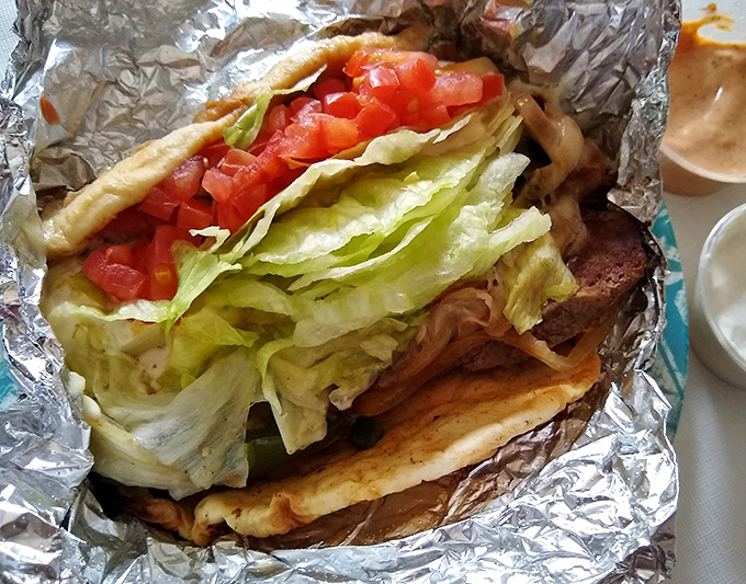This isn't just a gyro—it's edible architecture. Fresh veggies, seasoned meat, and tzatziki create the perfect handheld vacation to Greece.