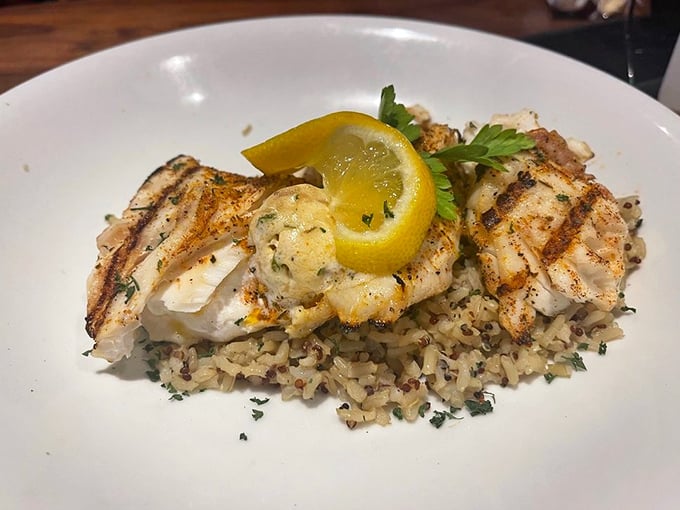 Perfectly grilled fish atop a bed of rice that didn't just phone it in. That lemon wedge isn't decoration—it's the finishing touch on a masterpiece.