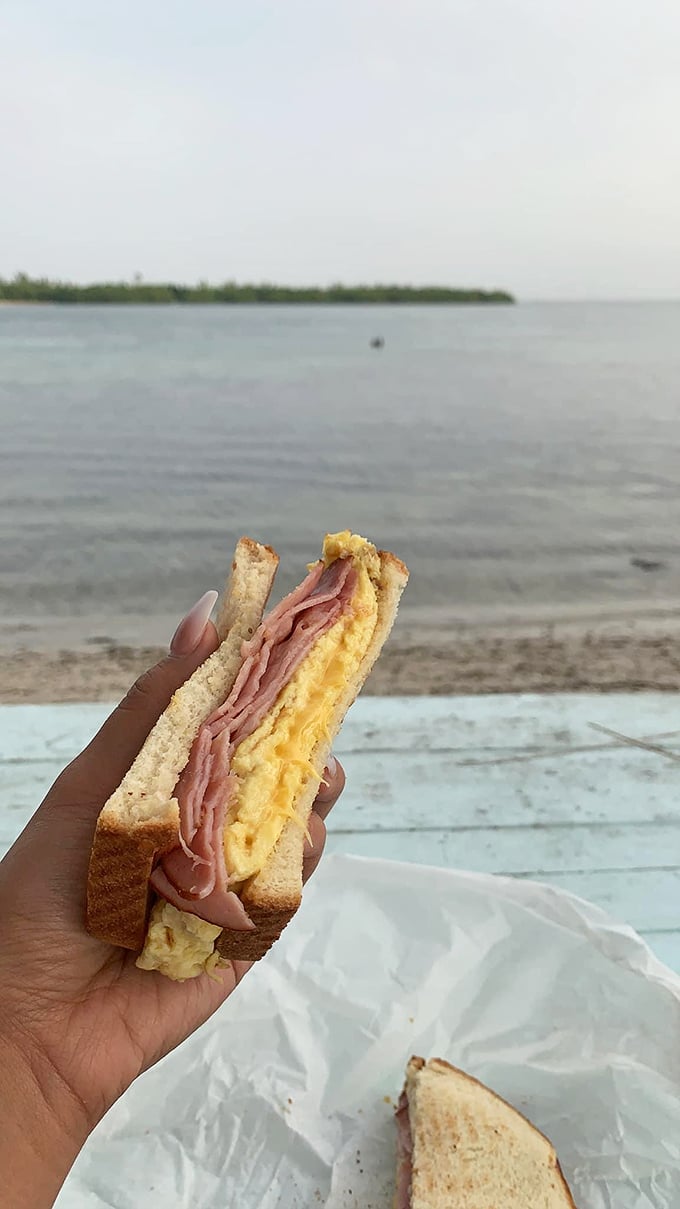 Behold the humble ham and egg sandwich, enjoying the best view in town. Some meals simply taste better with salt air and water lapping nearby.