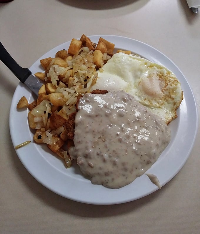 Breakfast alchemy at its finest—crispy home fries mingling with eggs and country gravy in a plate that screams "your diet starts tomorrow."