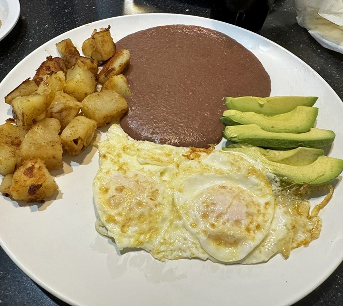 Sunny-side eggs, crispy home fries, and fresh avocado slices create the breakfast plate that launched a thousand satisfied sighs and "I'll have what they're having" moments.