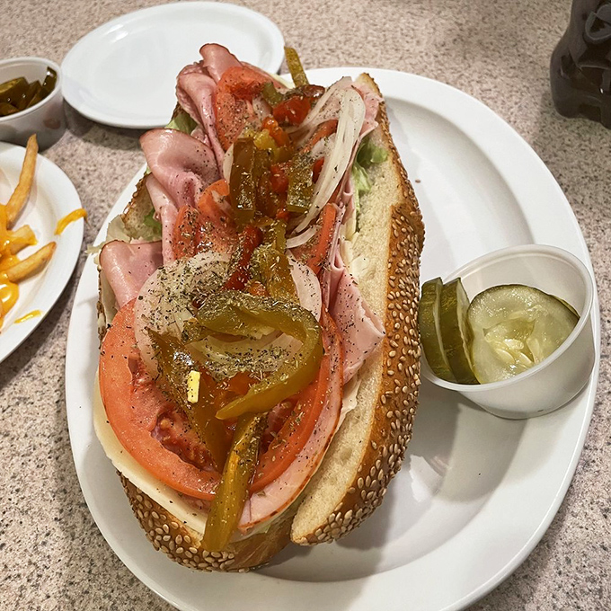 This isn't just a sandwich; it's an architectural marvel of meat, cheese, and vegetables balanced on a sesame-seeded foundation of perfection.