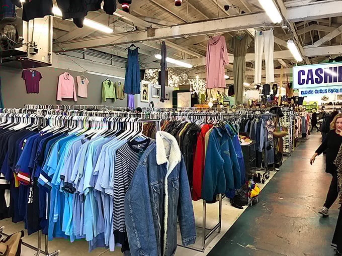 The blue shirt section alone could outfit a small navy. Note the strategic hanging of dresses overhead—vintage shopping in three dimensions.