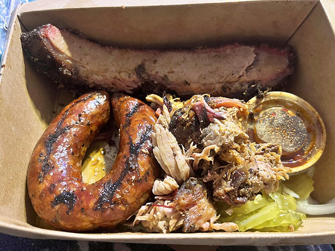 A cardboard container never held such treasure—sausage with the perfect snap, tender pulled pork, and a rib that's worth fighting over.