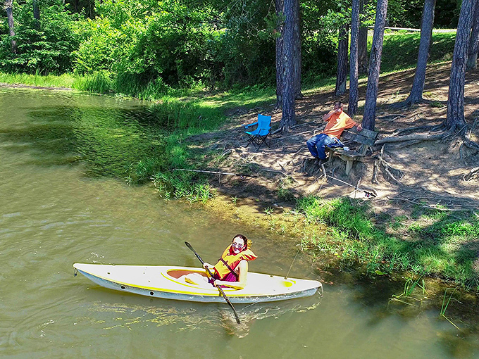 Childhood summers distilled into one perfect scene: a young kayaker explores the shoreline while adults keep watch—the original family entertainment system.