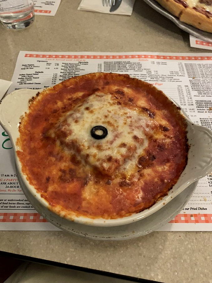 A personal-sized lasagna with a single olive sentinel standing guard. This isn't just comfort food—it's therapy without the hourly rate.