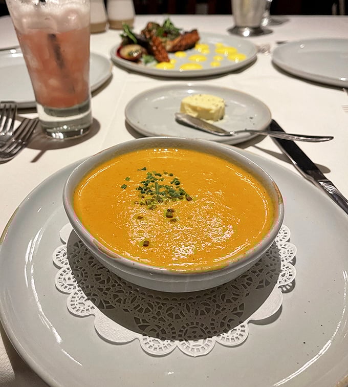 This lobster bisque doesn't just warm your stomach—it hugs your soul. The paper doily underneath is purely ceremonial; you'll want to lick the bowl.