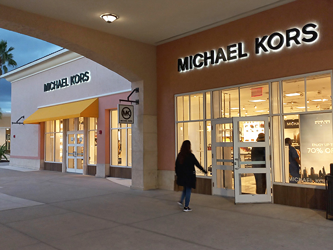 Michael Kors after sunset—when the serious shoppers emerge like retail vampires, hunting for handbags instead of hemoglobin.