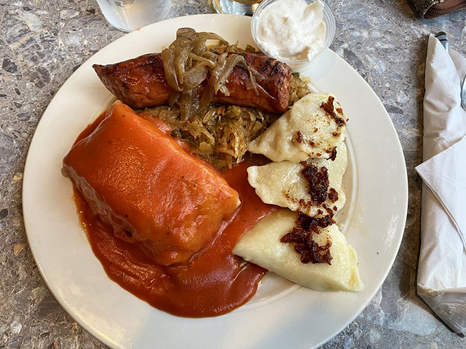 A Polish platter that would make Warsaw proud – golabki (stuffed cabbage) nestled alongside pierogi and kielbasa, all bathed in rich tomato sauce that demands to be sopped up.
