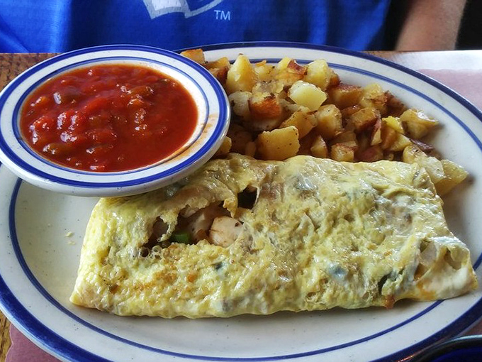 An omelet that doesn't just contain ingredients—it celebrates them, with home fries playing the perfect supporting role.