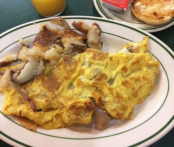 This isn't just an omelet—it's a golden-hued canvas of morning perfection with home fries that actually taste like they've met a potato.