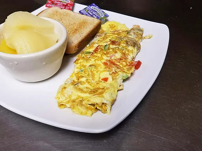 This omelet didn't just happen—it was engineered by someone who understands that breakfast is the most important art form of the day. Note the perfect fold technique!