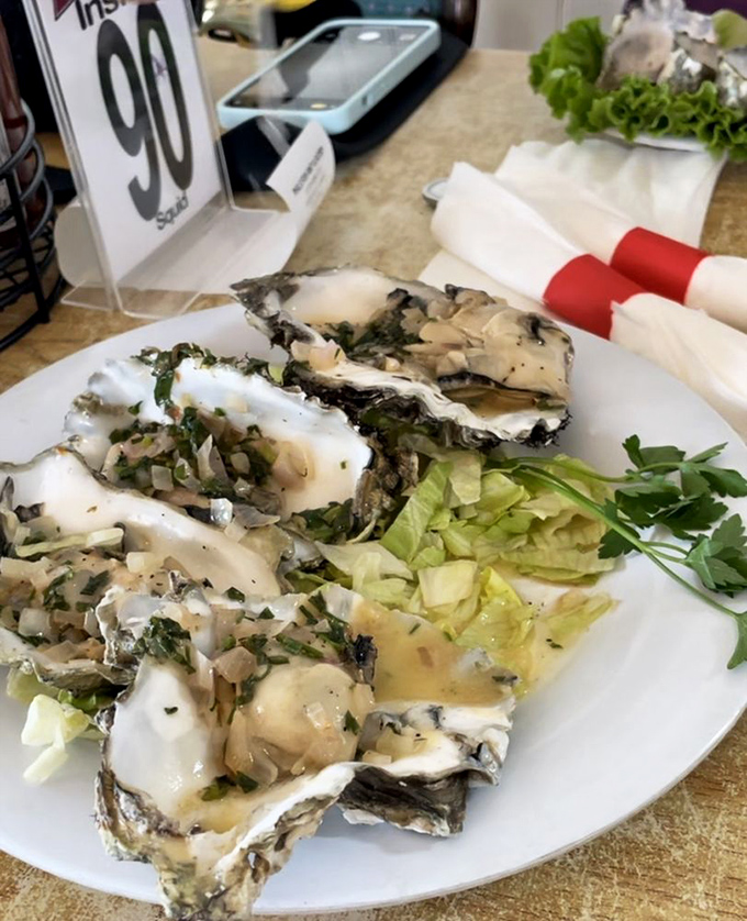 These oysters aren't just served; they're presented with the reverence of crown jewels, adorned with herbs and ready to slide down your throat like ocean-kissed silk.