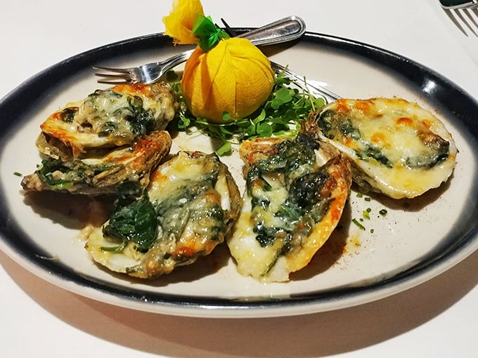 Oysters Rockefeller arrive like jewels on a plate – briny treasures beneath a blanket of spinach, cheese, and buttery breadcrumbs.