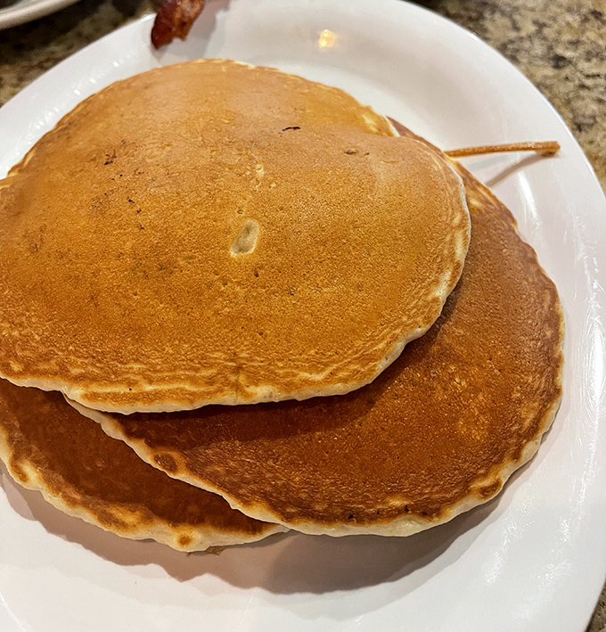 Pancakes so perfectly golden and fluffy they could moonlight as pillows. These breakfast frisbees demand respect – and real maple syrup.