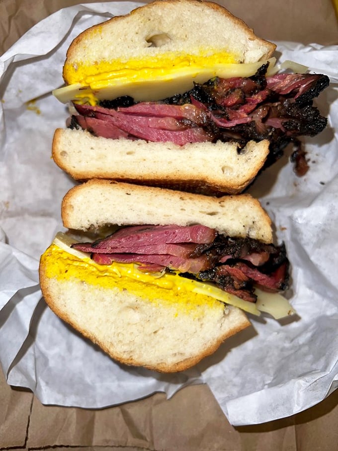 A proper pastrami sandwich should require both hands and a strategy. This masterpiece demands respect, mustard, and possibly a nap afterward.