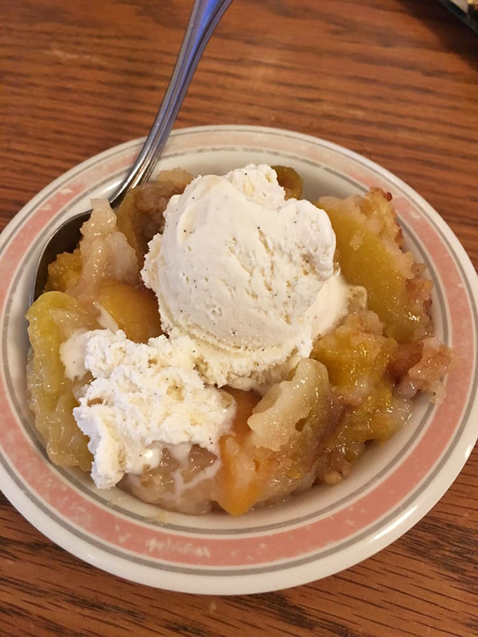 Peach cobbler with ice cream melting into warm fruit—proof that sometimes the simplest pleasures are worth driving across three counties for.