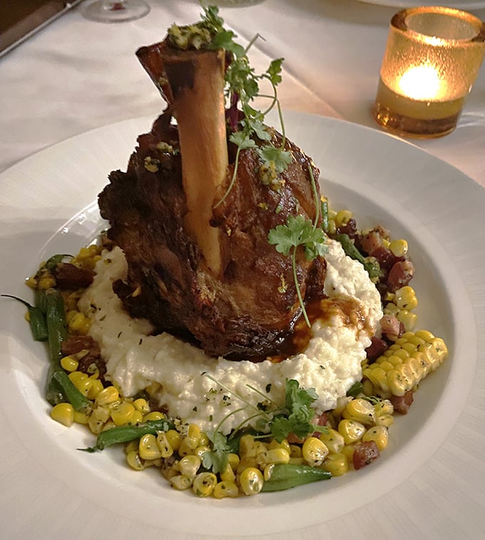 This lamb shank doesn't just fall off the bone – it practically leaps onto a cloud of creamy grits surrounded by a summer cornucopia.