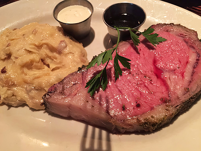 The prime rib arrives like royalty on a white throne, its rosy interior revealing the kitchen's perfect understanding of "medium-rare" and time management.