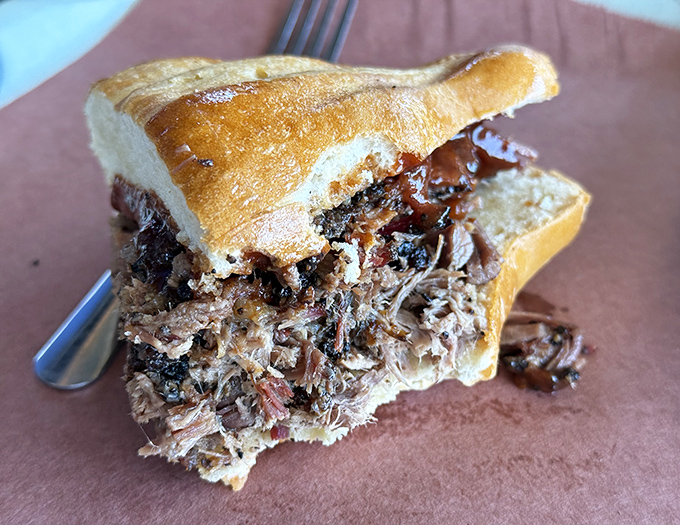 This pulled pork sandwich isn't just a meal—it's an architectural achievement of tender, smoky meat threatening to escape its bread boundaries.