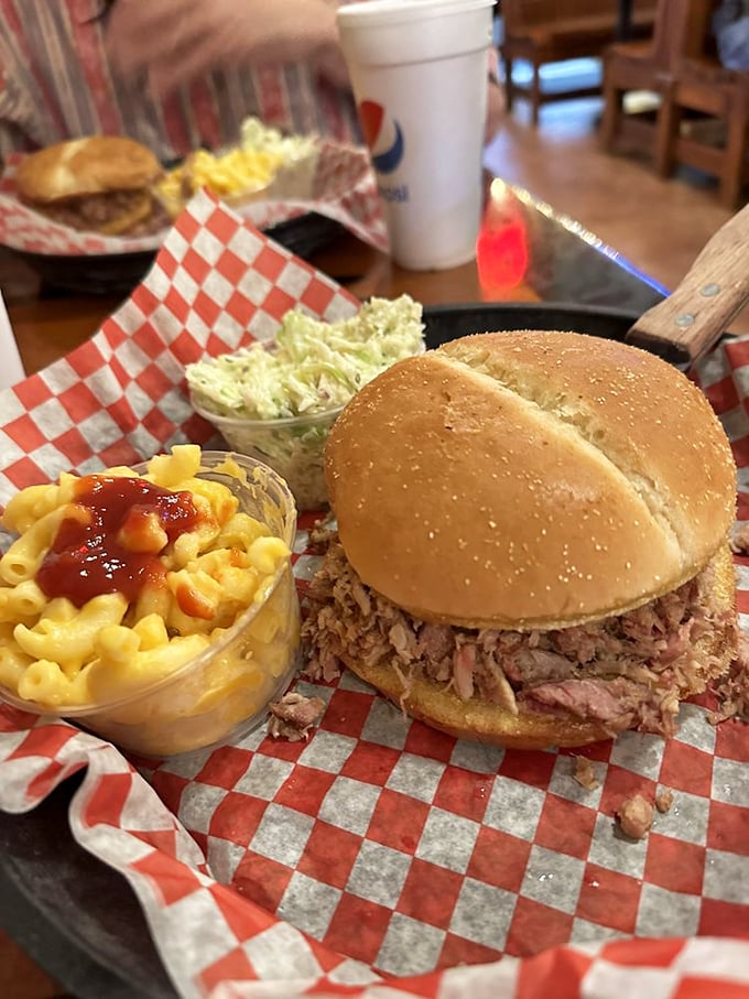 A pulled pork sandwich that requires strategic eating and zero shame. The mac and cheese isn't a side—it's an essential supporting character.