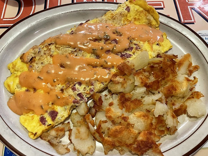 When an omelet meets thousand island dressing, it's not just breakfast—it's a flavor revolution with perfectly crispy home fries standing guard.
