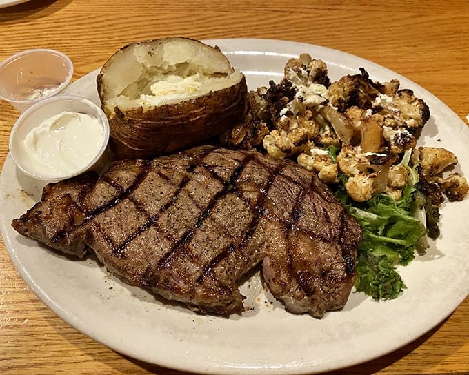 This perfectly cross-hatched ribeye isn't just a steak – it's a carnivore's geometry lesson that pairs beautifully with that loaded baked potato.