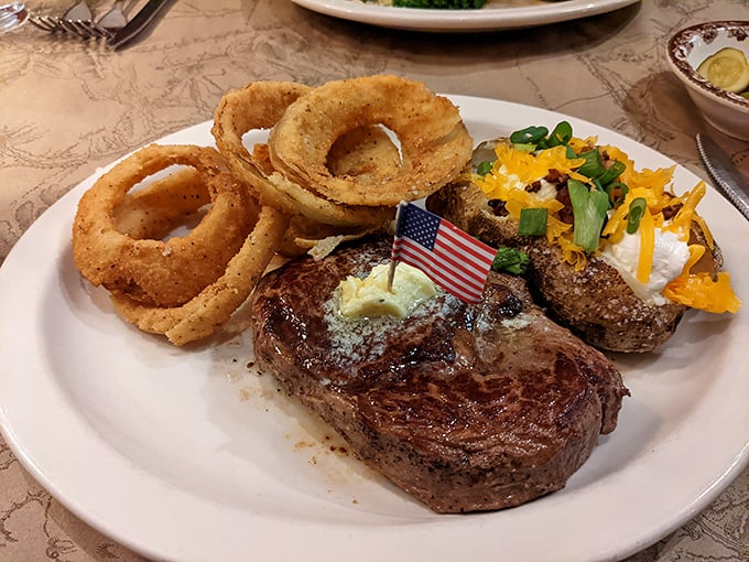 This isn't just a steak—it's a celebration on a plate, complete with those golden onion rings standing at attention like delicious sentries.