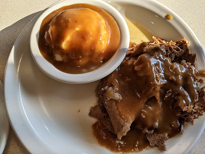 Mashed potatoes drowning in gravy next to fork-tender roast beef. The kind of plate that makes you want to hug the cook.