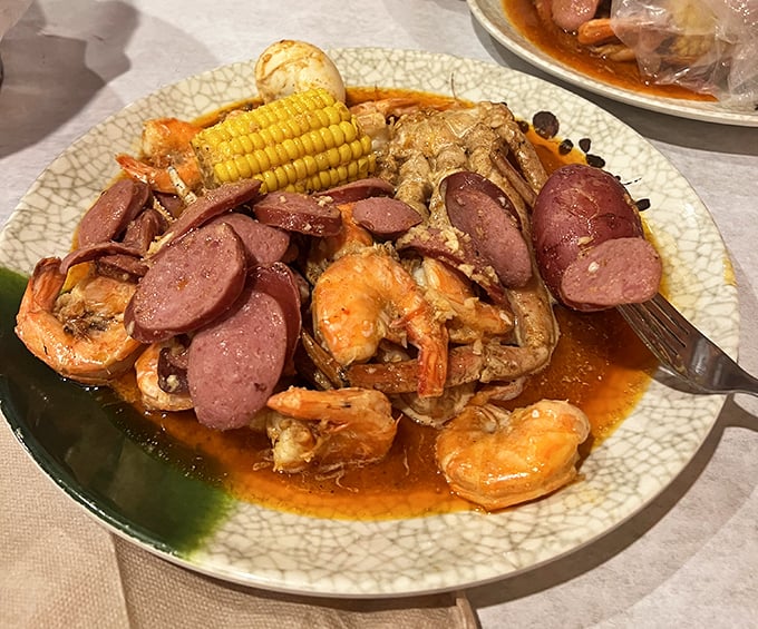 The seafood boil arrives like a greatest hits album of the ocean—shrimp, sausage, corn, and potatoes swimming in a spicy broth that demands to be sopped up with bread.