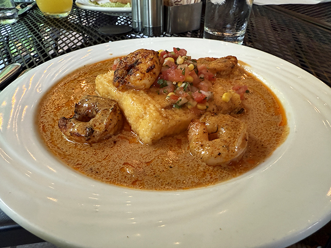 Shrimp and grits elevated to an art form—plump crustaceans lounging on a golden polenta island in a sea of savory sauce.