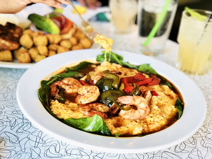 Shrimp and grits that would make a Southerner weep with joy—plump shrimp nestled on creamy grits with vegetables adding pops of color like confetti at a flavor party.