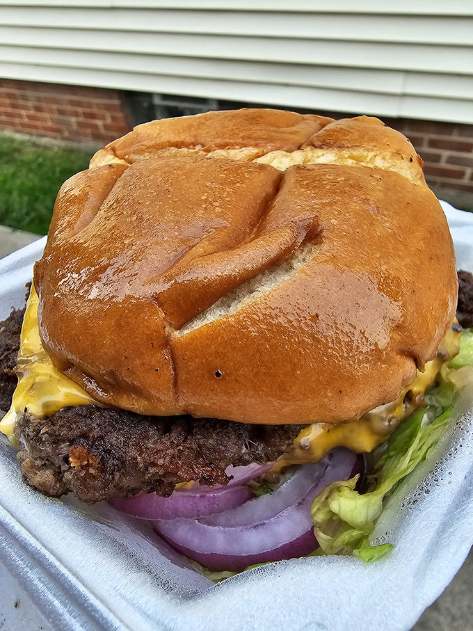 This isn't just a burger—it's an architectural marvel. The brioche bun struggles heroically to contain a patty that's been smashed into submission and crowned with melty American cheese.