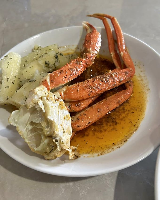 Snow crab legs bathed in herb-infused butter—nature's perfect design for making adults look like messy, utterly content children at the dinner table.
