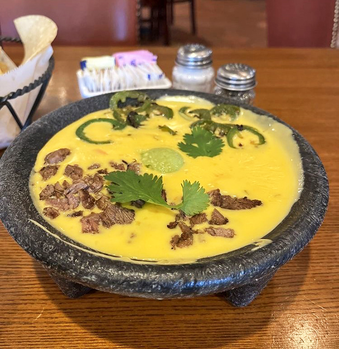 The legendary Bob Armstrong Dip – where queso meets guacamole, ground beef, and cilantro in a molcajete of pure genius.