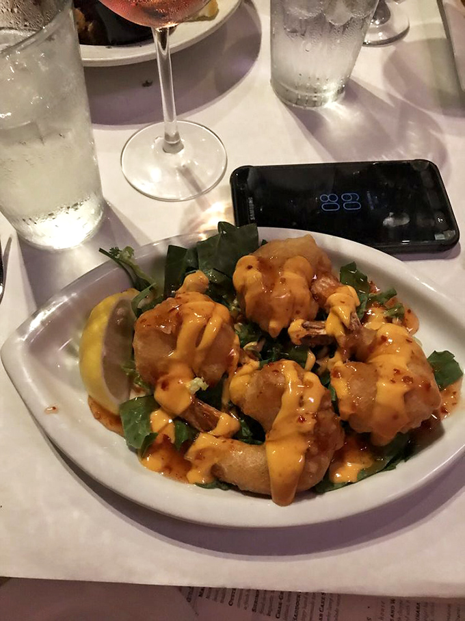These golden shrimp, glistening with spicy sauce, aren't just appetizers—they're conversation starters that silence the table until the last bite.