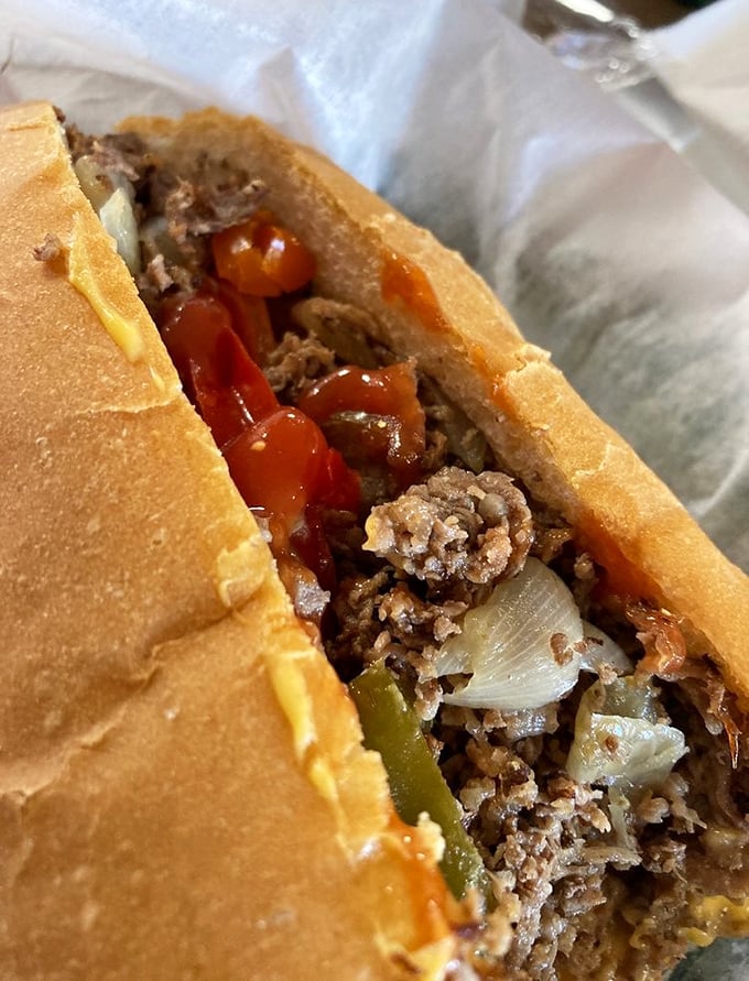 The cross-section reveals the architecture of deliciousness—layers of seasoned meat, melted cheese, and caramelized onions creating a harmony of flavors.